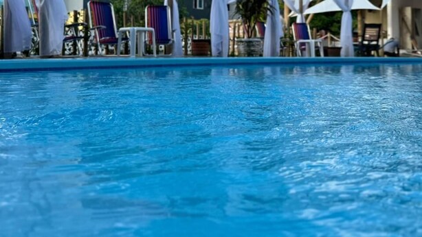 Piscina com toldos brancos e espreguiçadeiras.