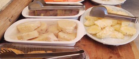 Uma mesa de buffet com diversos alimentos e utensílios de servir.