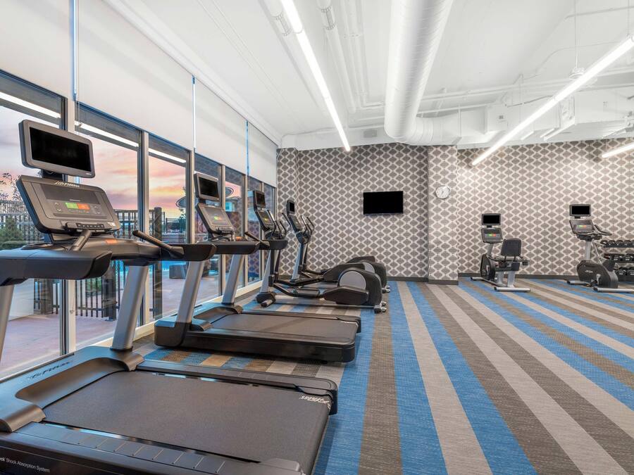 Academia com esteiras, elípticos e estações de musculação.