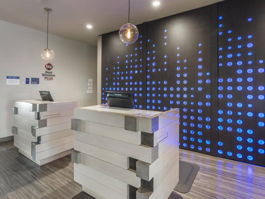 Uma receção com design moderno, um logótipo na parede e um elemento decorativo com padrão.