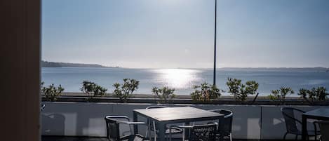 Um terraço com vista para o mar, com área de estar ao ar livre e um poste de luz.