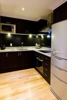 Um frigorífico/congelador grande, um micro-ondas, um forno 