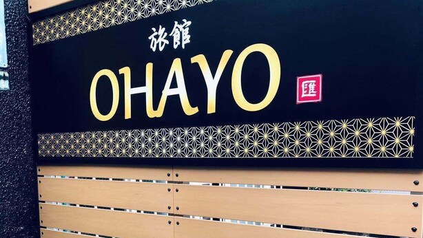 Placa de hotel com o nome 'OHAYO' e um padrão decorativo.