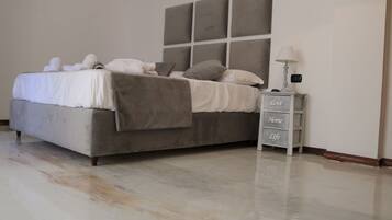 Um quarto moderno com uma cama grande, uma mesinha de cabeceira e uma luminária fixada na parede.