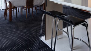 Uma área de refeições moderna com mesa, cadeiras e banquetas.