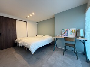 Um quarto com uma cama, uma escrivaninha e uma cadeira.