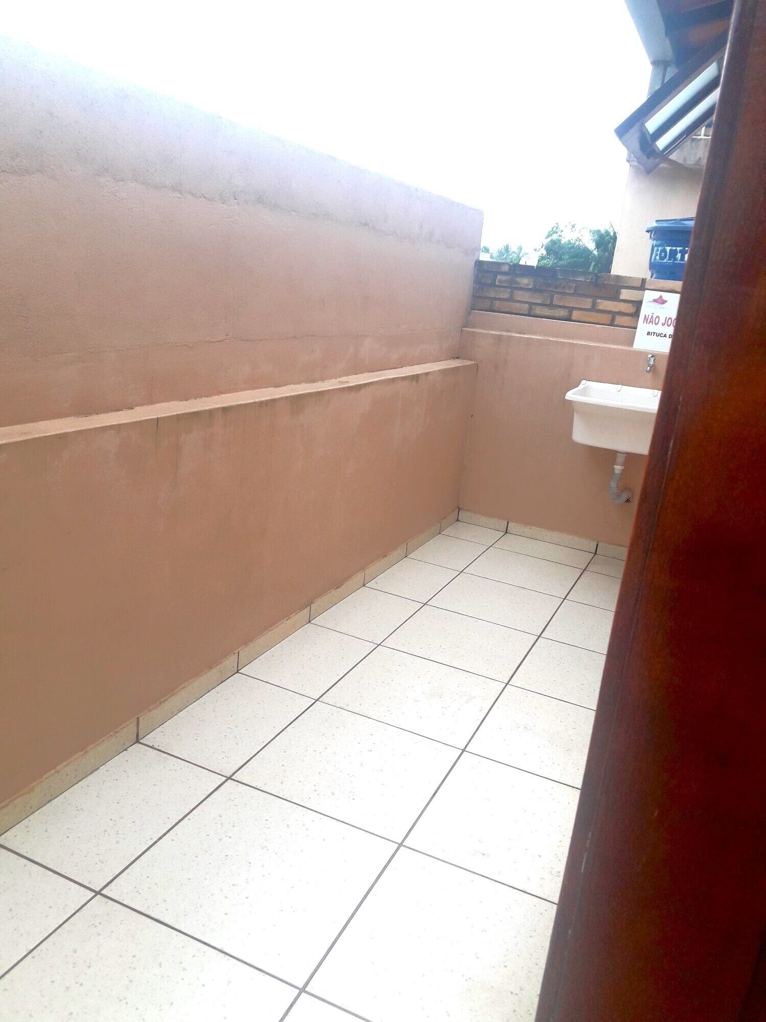Casa de banho pequena e fechada, com chão em mosaico e lavatório.