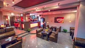 Um hall moderno com assentos de couro, espaço de bar e máquina de vendas.