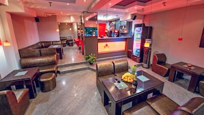 Uma área de estar moderna com assentos de couro, um bar e uma mesa de frutas.