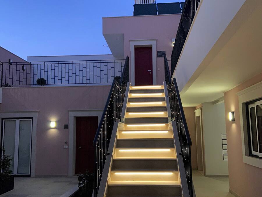 Escadaria iluminada que leva à entrada de um edifício.