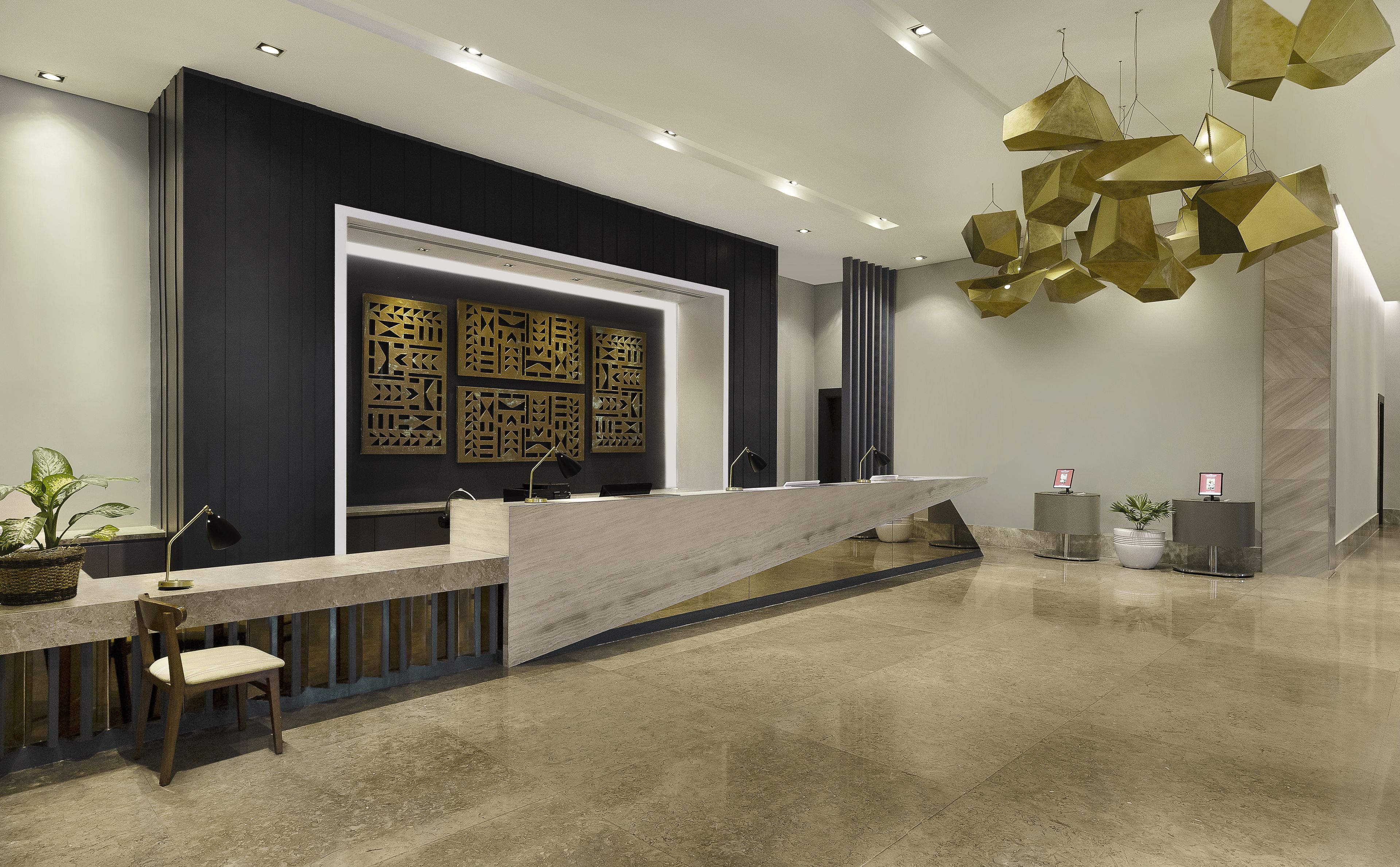 Uma área de recepção moderna com balcão de mármore, uma cadeira de madeira e um painel decorativo na parede.