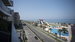 Um hotel à beira-mar com piscina, escorrega aquáticos e vista para o mar.