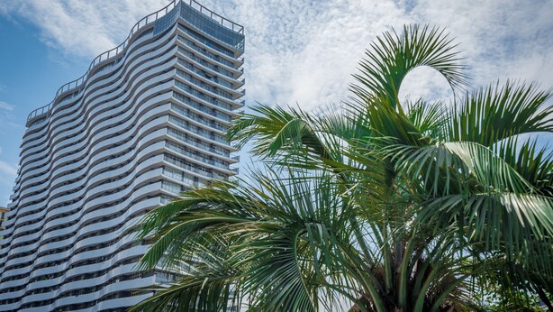 Um edifício alto com fachada ondulada e varandas.
