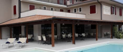 Um hotel com piscina, área de estar externa e uma placa com a inscrição 'FORTUNA'.