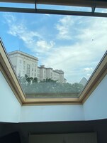 Um claraboia com vista para um edifício alto e árvores.