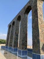 Uma construção de pedra com várias arcos e piso em mosaico.