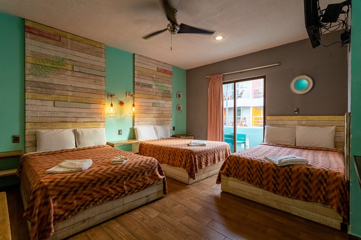 Quarto, várias camas, sacada, vista para a cidade | Frigobar, cofres nos quartos, Wi-Fi de cortesia, roupa de cama
