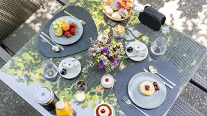 Uma mesa posta para refeição, com pratos, talheres e diversos alimentos.