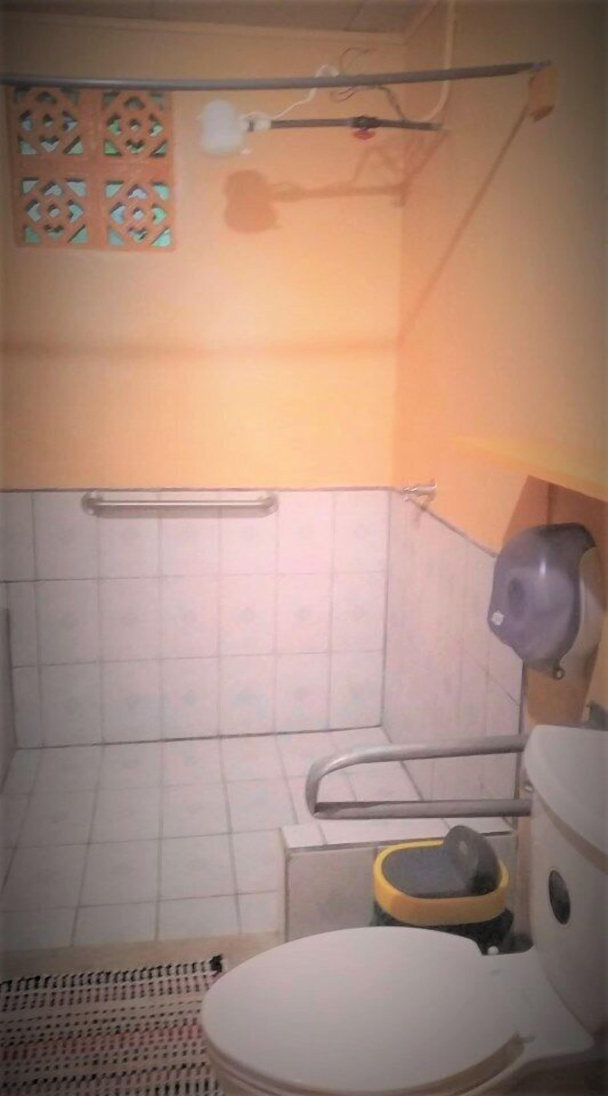 Uma casa de banho pequena com sanita, zona de duche e lavatório.