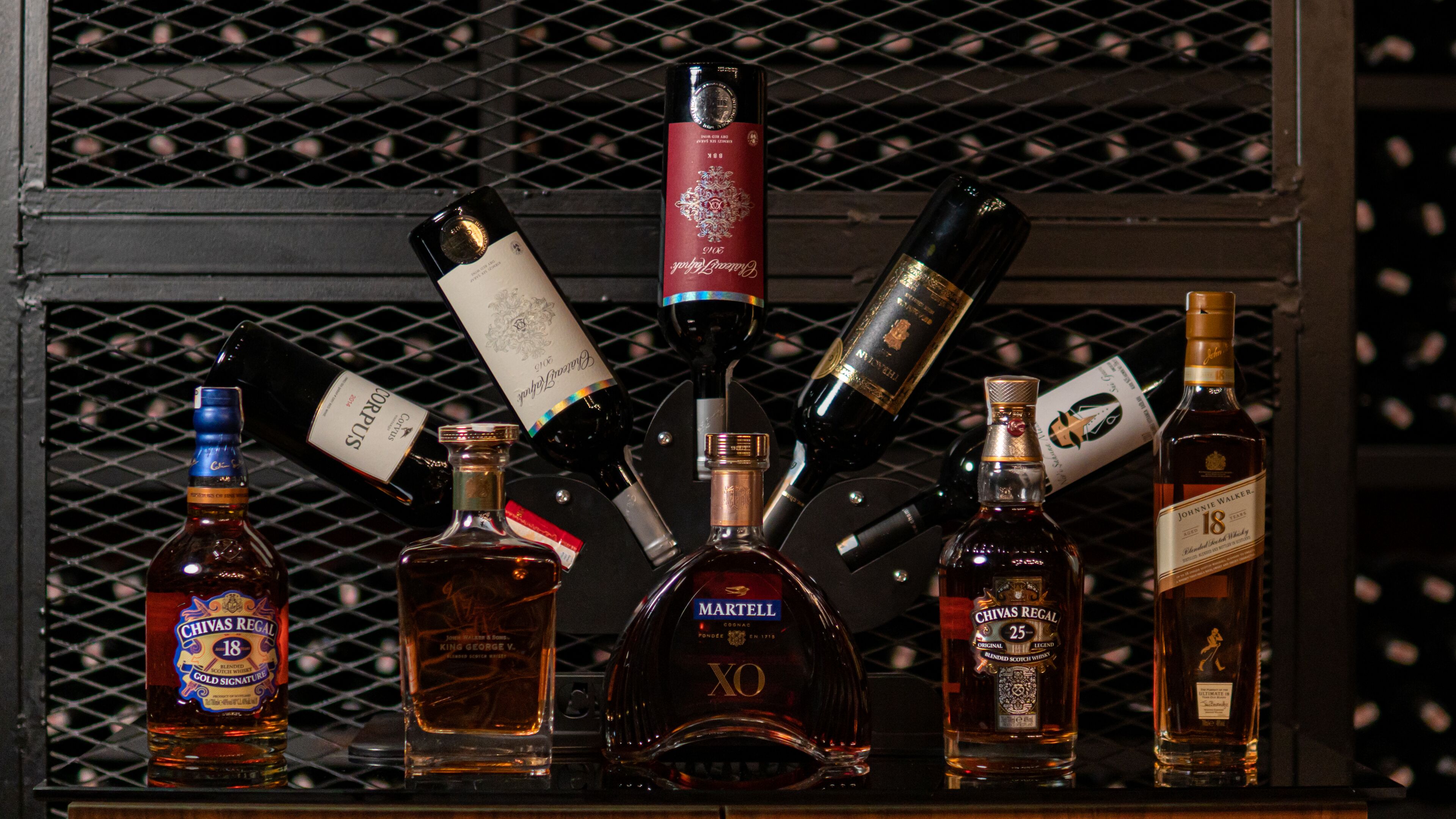 Uma seleção de garrafas de bebidas alcoólicas expostas numa estante.