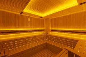 Uma sauna com bancos de madeira e teto inclinado.