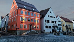 Um edifício histórico com fachada vermelha e uma placa com a inscrição 'Stadthotel'.