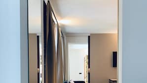 Quarto de hotel moderno com cama, escrivaninha e televisão.