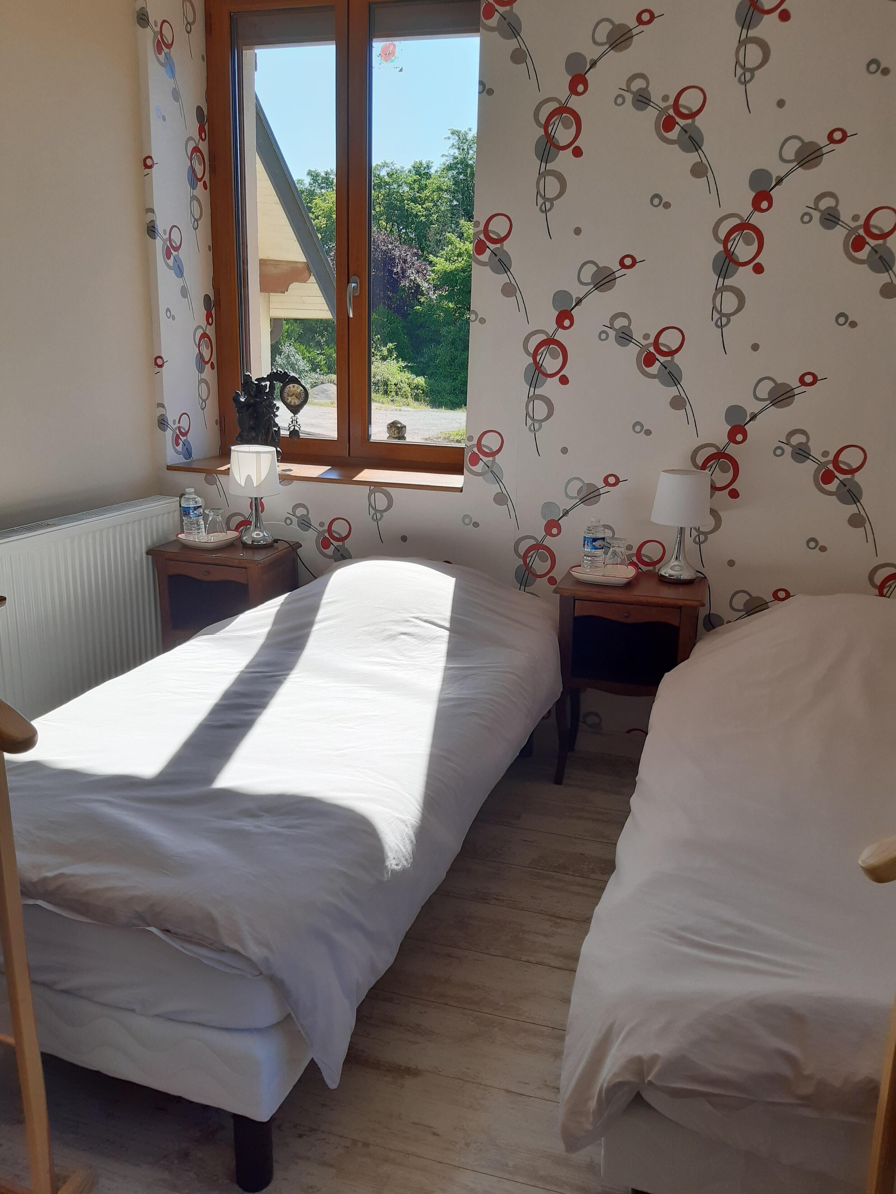 Quarto com duas camas, uma janela e um radiador.