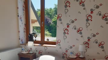 Quarto com duas camas, uma janela e um radiador.