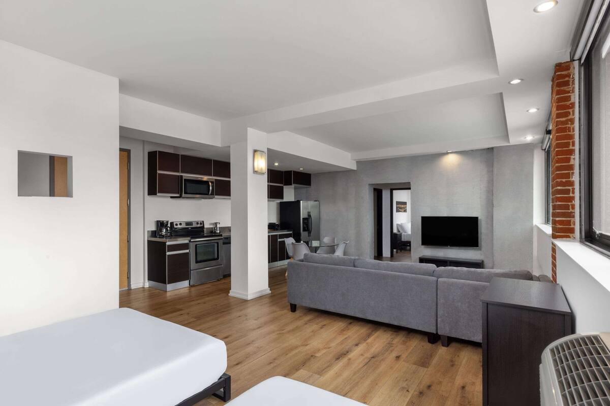 Um apartamento moderno com cozinha, sala de estar e televisão.