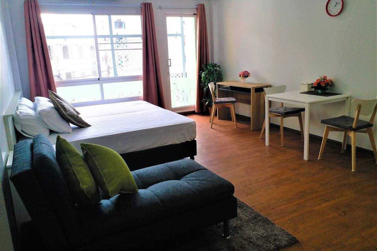Quarto com cama, sofá, escrivaninha e cadeira.