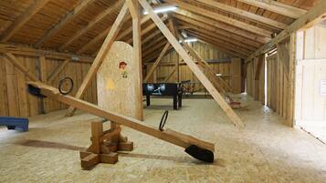 Sótão com vigas de madeira, um balanço e piso de madeira.