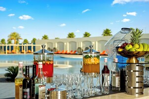 Uma área de bar com vista para a piscina, com diversos frascos e copos.