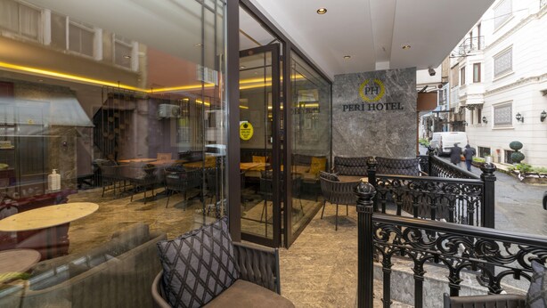 Um Perihotel moderno com fachada de vidro, área de estar ao ar livre e vista para a rua.