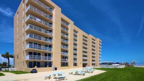 Um hotel com vários andares, varandas, área de estar ao ar livre e piscina.
