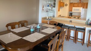 Uma área de refeições com uma mesa de madeira, quatro cadeiras e um ventilador de teto.