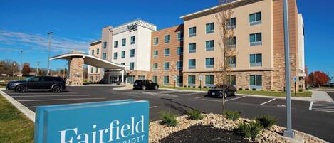 Um hotel Marriott Fairfield com design moderno, apresentando uma entrada imponente e um estacionamento.