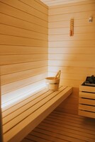 Uma sauna de madeira com bancos e um balde de madeira.