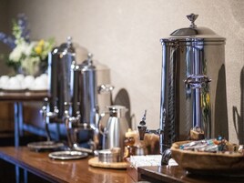 Uma mesa de buffet com diversos recipientes de comida e utensílios de servir.