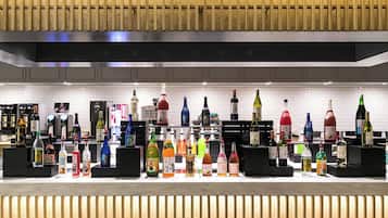 Uma área de bar com uma variedade de garrafas expostas em prateleiras.