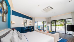 Quarto de hotel moderno com uma cama grande, uma escrivaninha e vista para o mar.