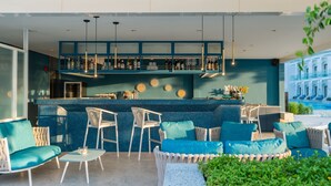Uma área de bar moderna com assentos e vista para a piscina.