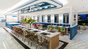 Uma sala de jantar moderna com uma mesa comprida, cadeiras e uma ilha central.