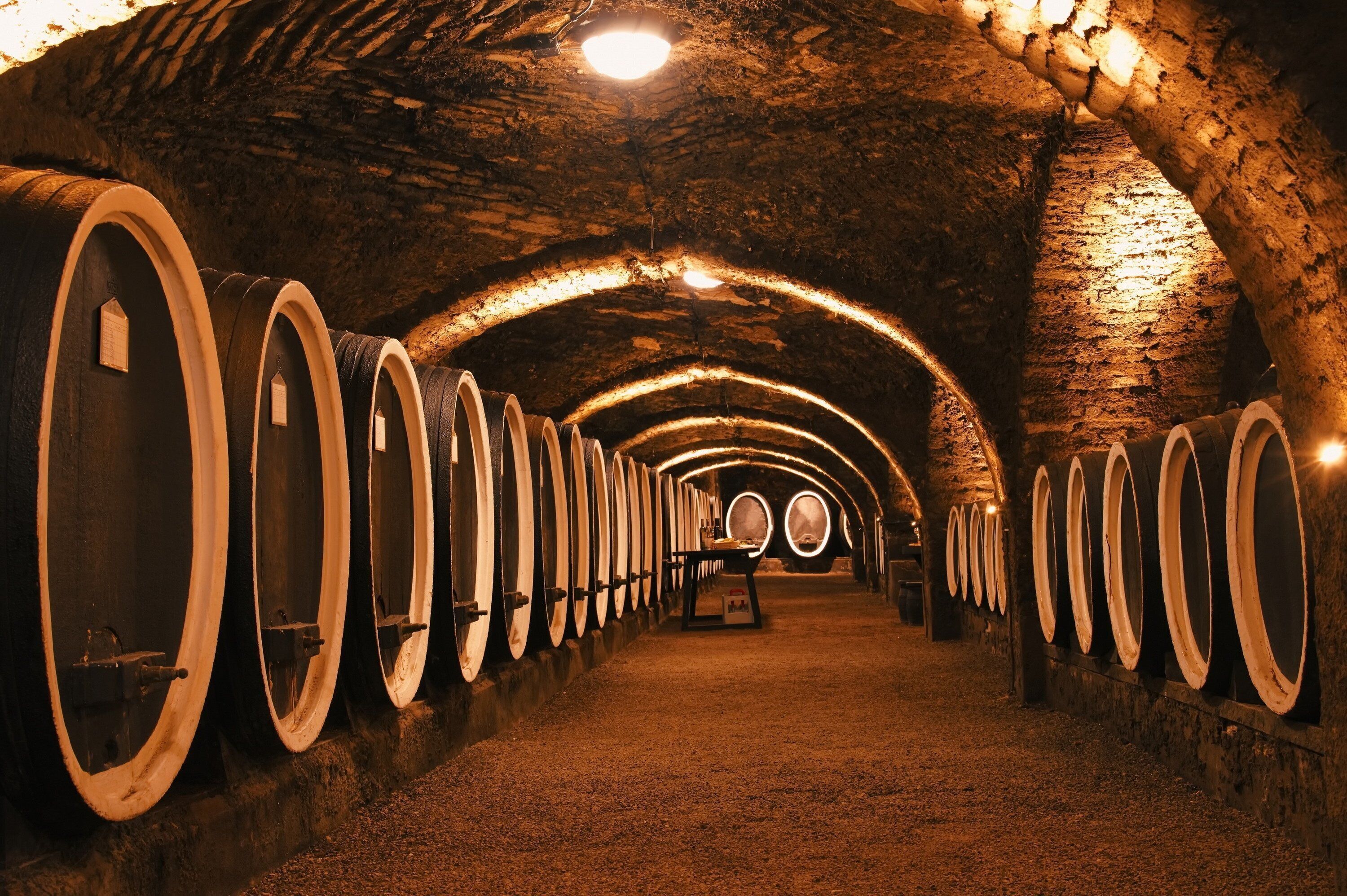 Um túnel com fileiras de barris de vinho.