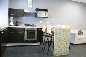 Um frigorífico/congelador grande, um micro-ondas, uma placa de cozinha 