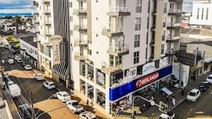 Um hotel com design moderno, várias varandas e uma loja visível chamada 'Berlanda' no andar térreo.