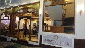 The Seasons Thekkady Business & Leisure Hotel com uma entrada imponente, uma escadaria e decoração natalina.