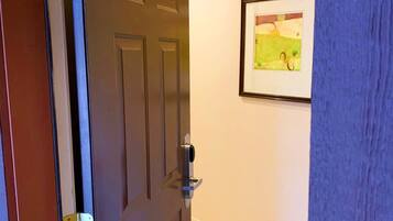 Uma porta fechada com uma placa que diz 'ENTRADA' e uma imagem na parede.