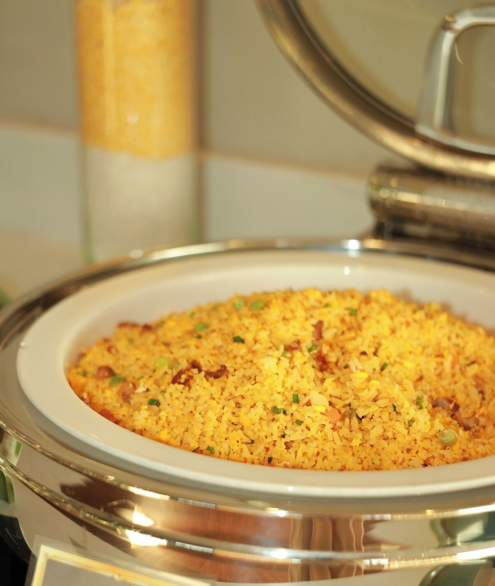 Uma tigela de arroz frito com ingredientes visíveis como ervilhas e ovos mexidos.