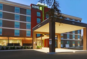 Um hotel com fachada moderna, vários andares e área de entrada coberta.
